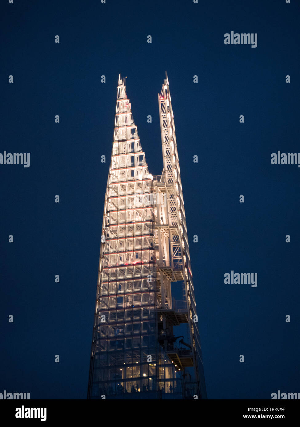 The top of the Shard, lit up at night against a deep blue sky Stock ...