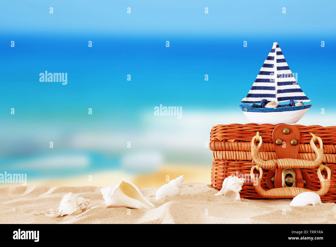Beach straw suitcase and wooden boat in the sand. Tropical summer ...