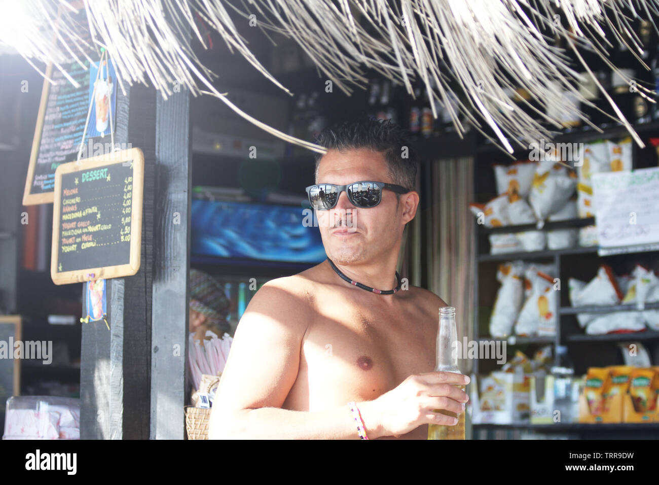 Young man enjoying beer and sunset in a beach bar Stock Photo - Alamy