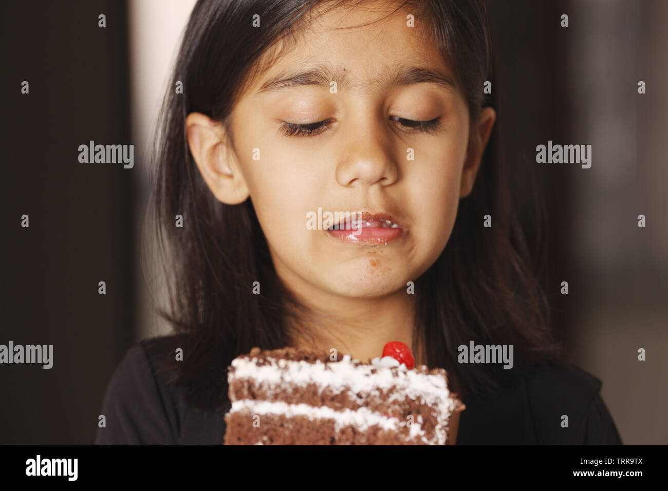 Girl eating a slice of cake Stock Photo - Alamy