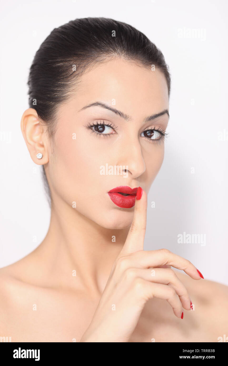Portrait of an Indian young woman with a finger on lips Stock Photo - Alamy