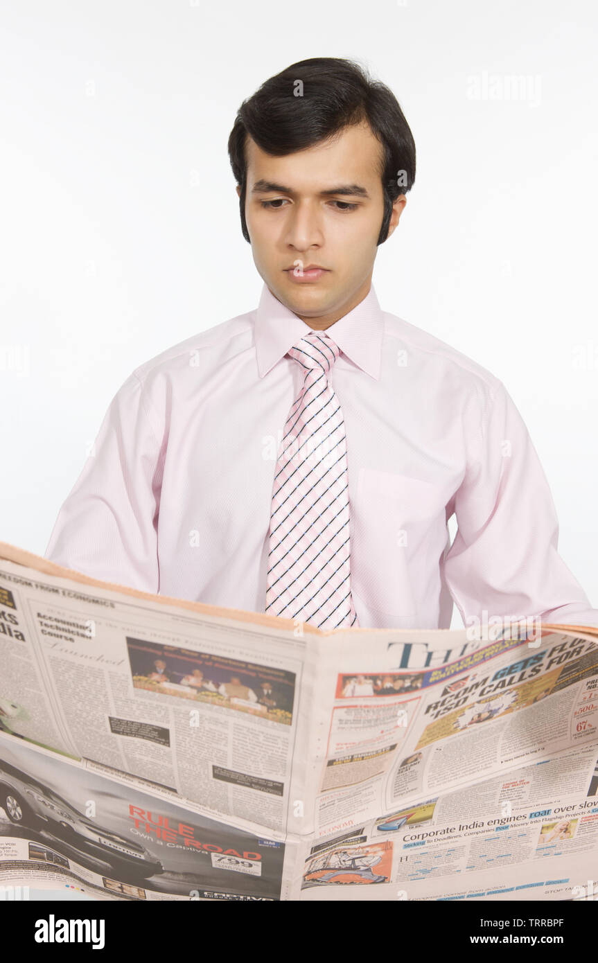 Businessman reading a newspaper Stock Photo - Alamy