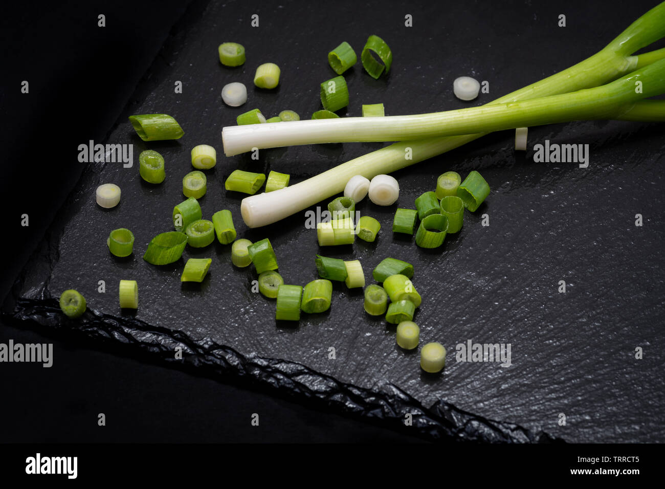 Organic Green Onion Scallions arranged on black natural stone ...