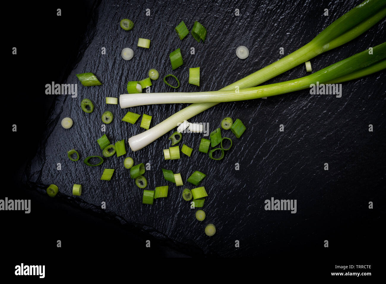 Organic Green Onion Scallions arranged on black natural stone ...