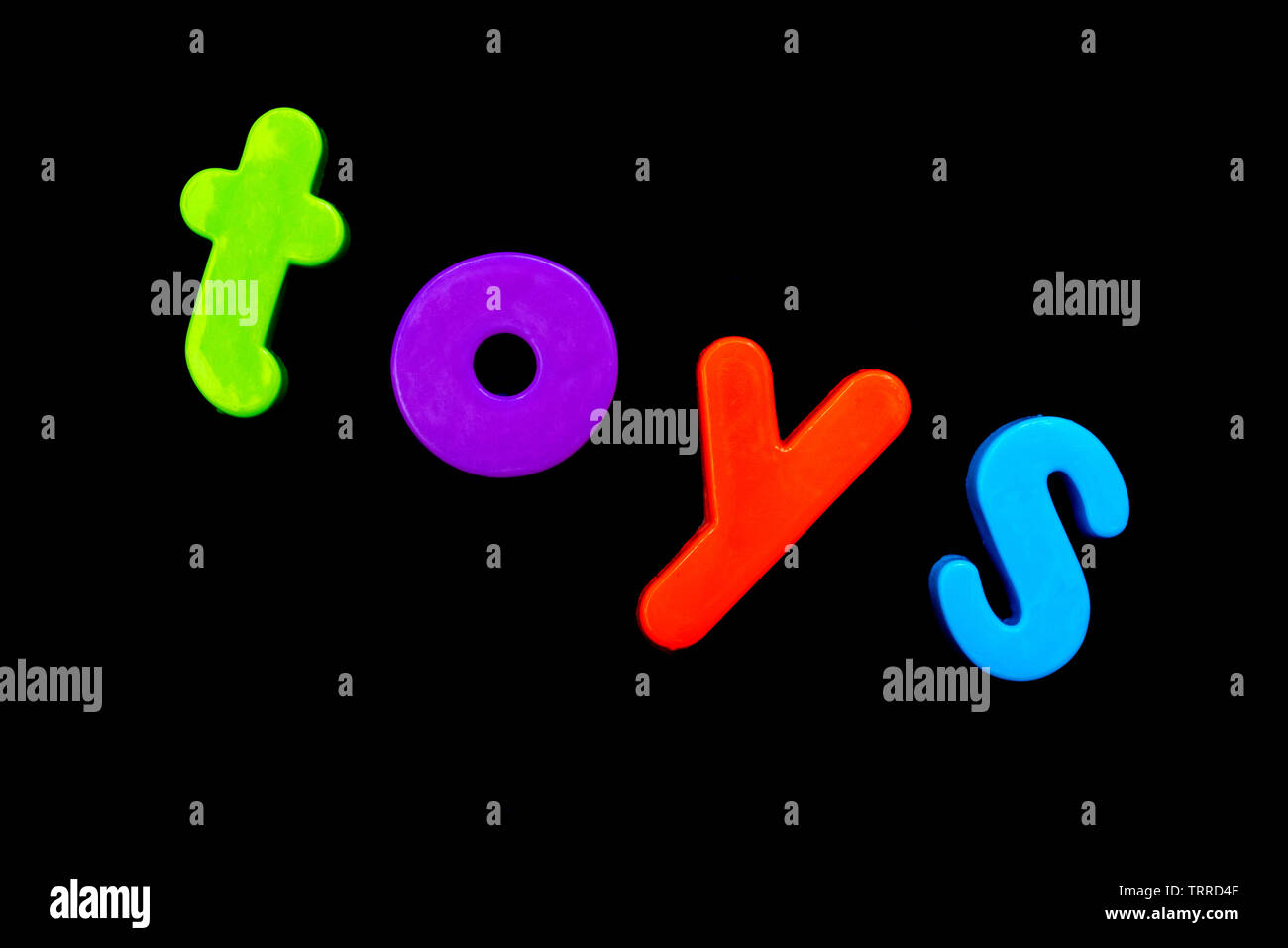 The word TOYS spelt with brightly coloured letters over a black ...