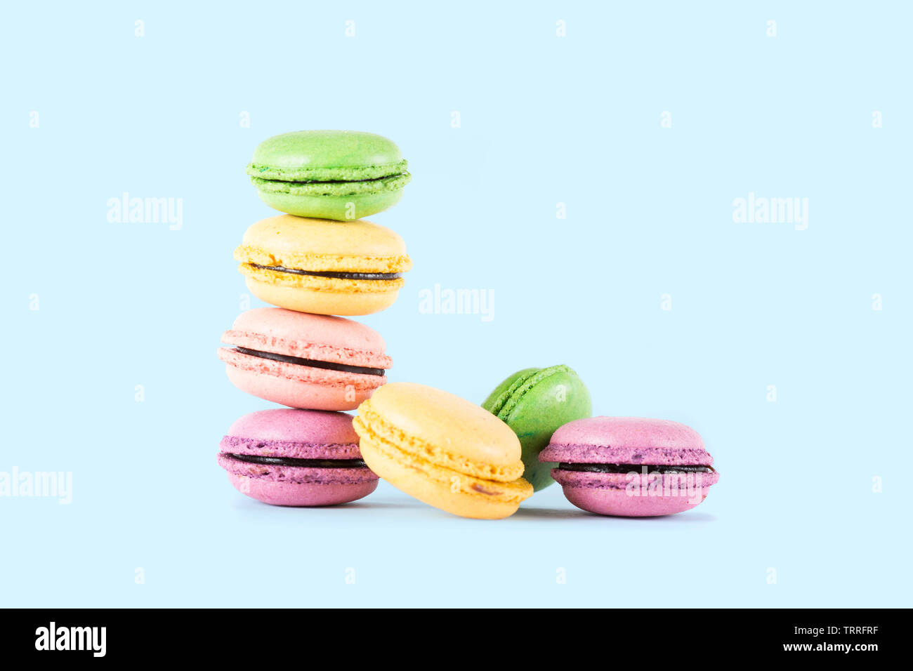 Macarons stacked in a row isolated on blue background Stock Photo - Alamy