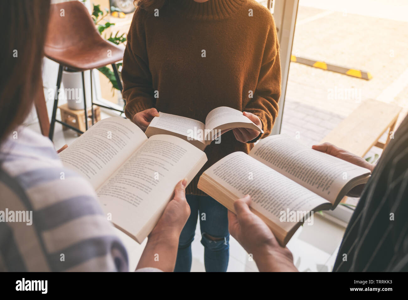 Three young people standing in circle and enjoyed reading books ...
