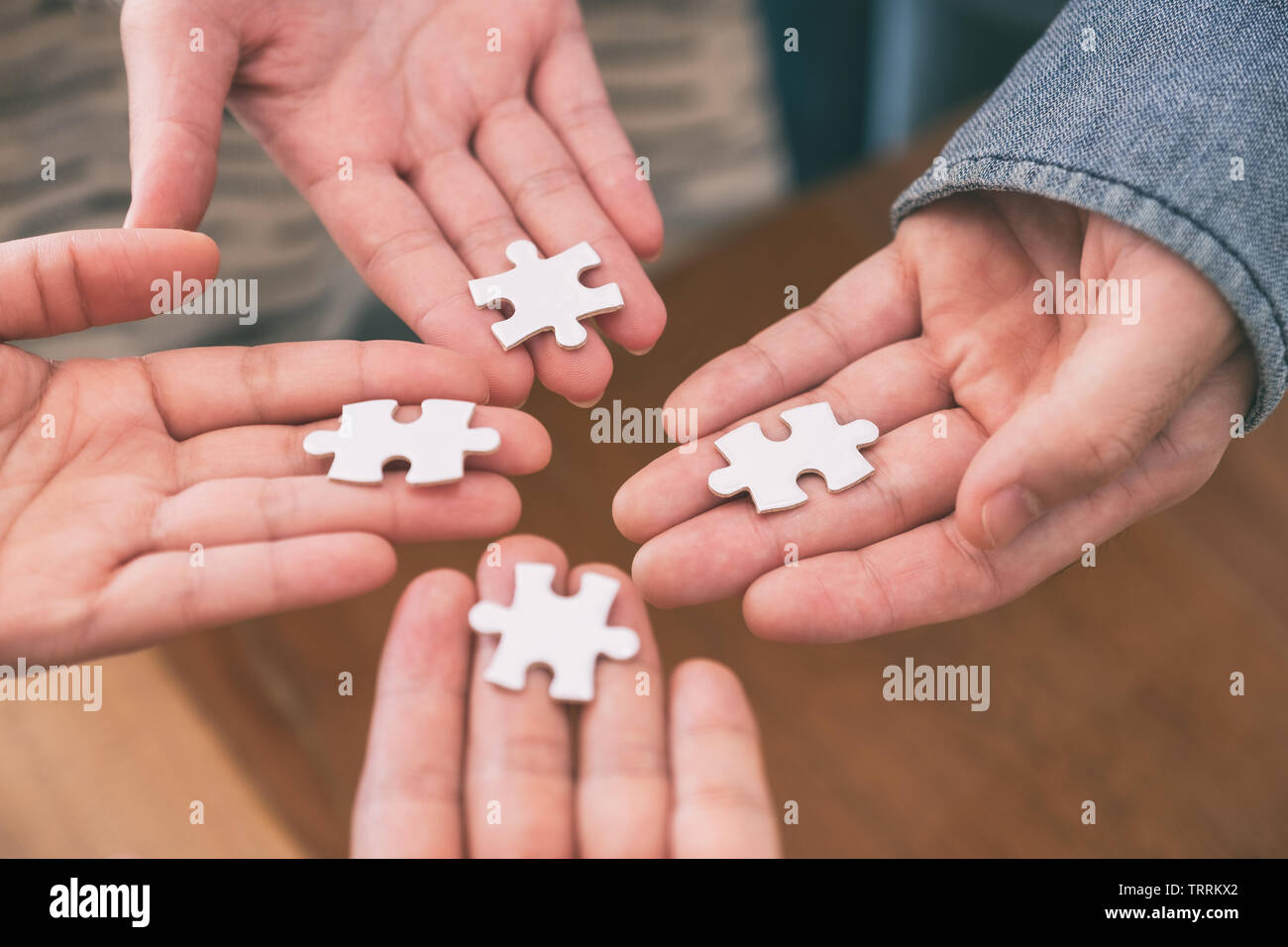 Closeup image of many people hands holding and putting a piece of white ...