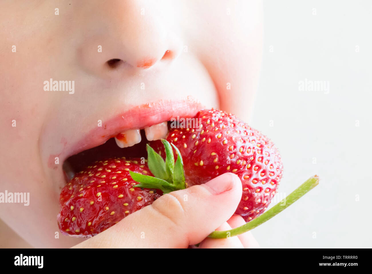 Man eats strawberries. Berry in the mouth. Small child or baby eating ...