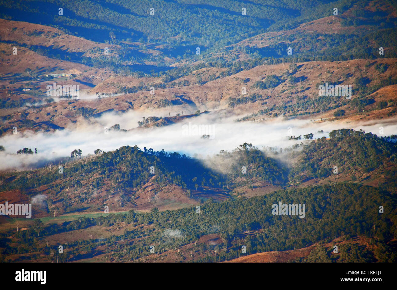 Low-lying mist sits in a valley behind a row of hills in the Gold Coast ...