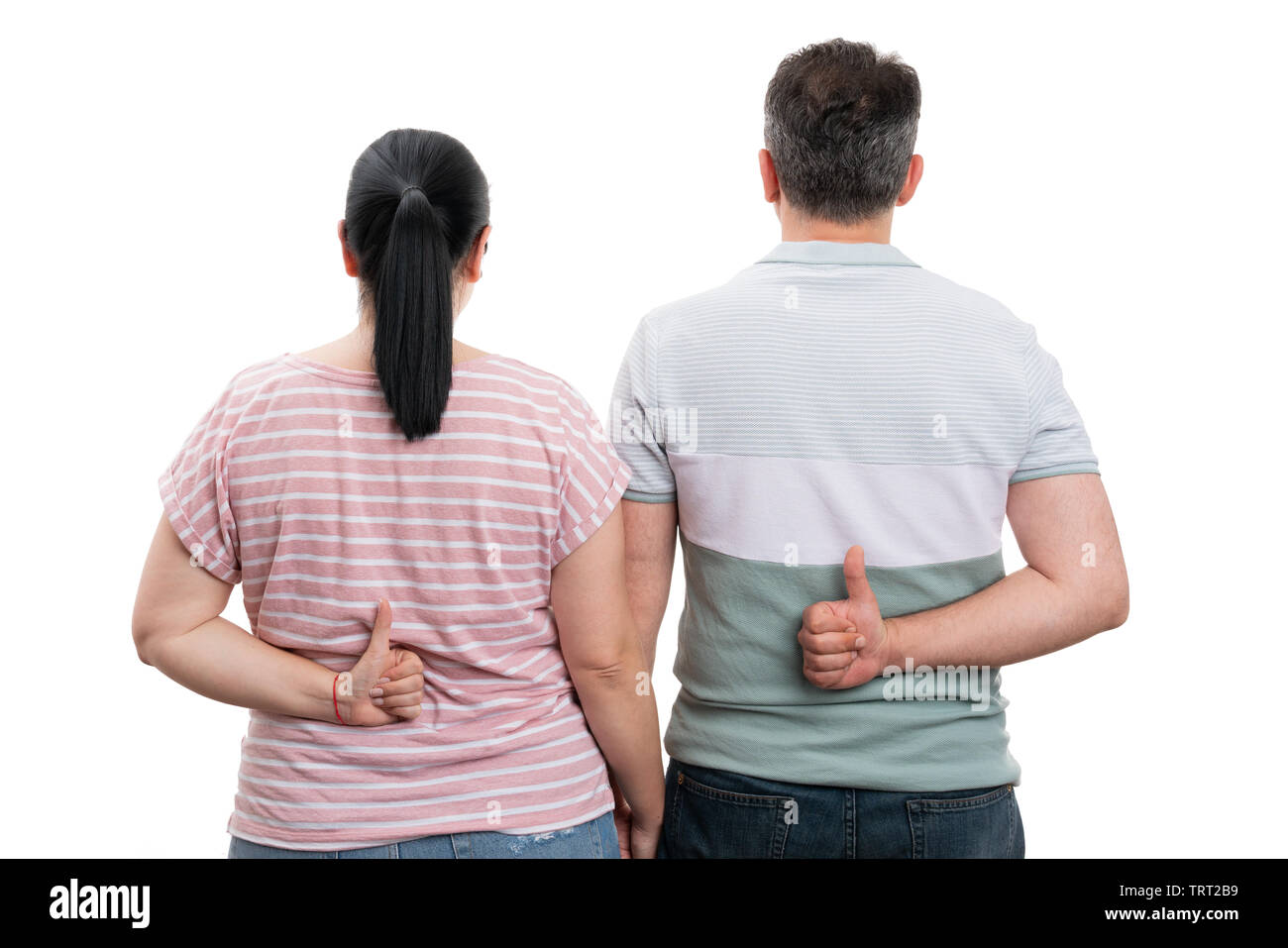 Couple holding thumbs up as like gesture behind back isolated on white ...