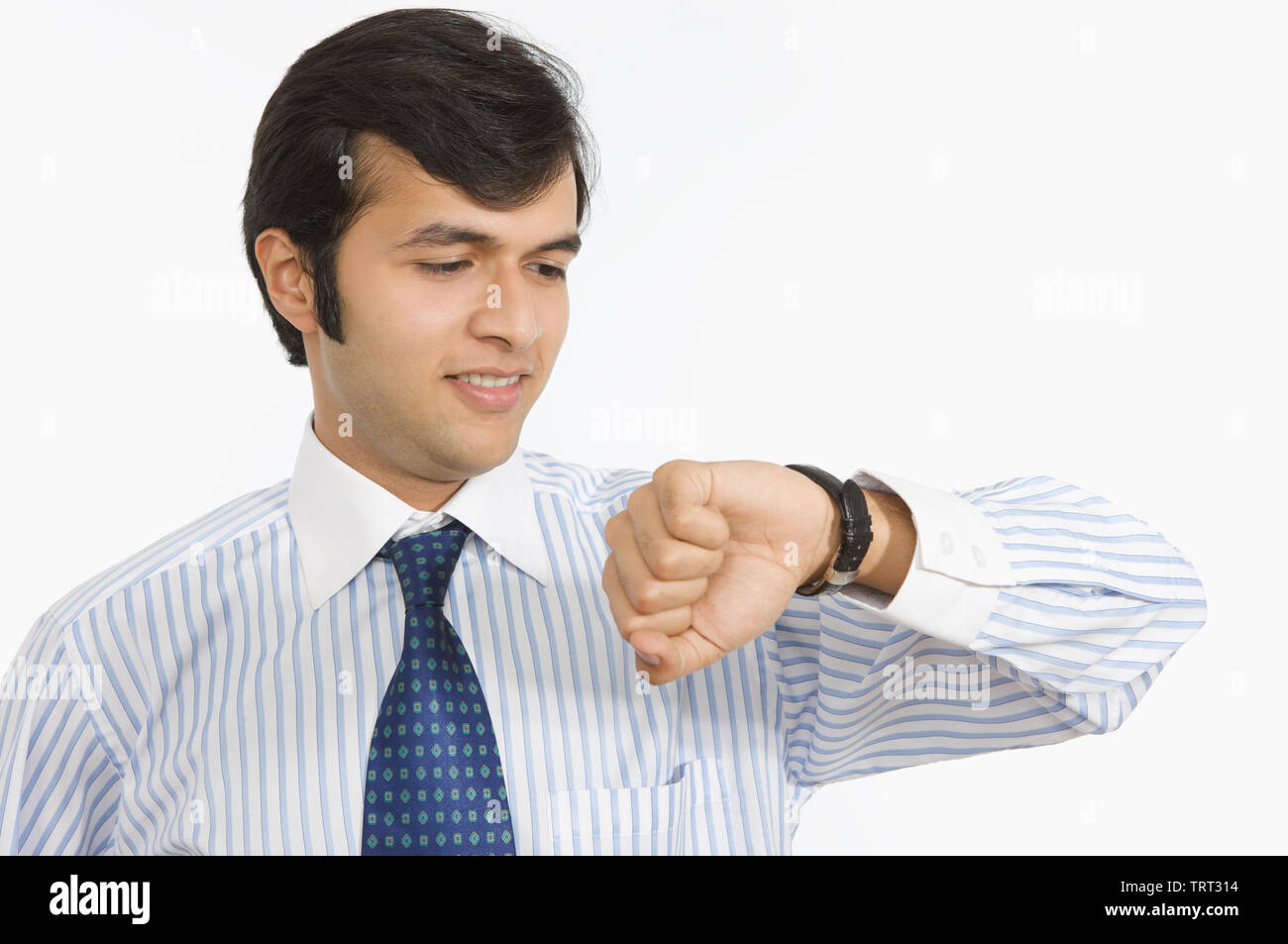 Indian businessman looking at his wristwatch Stock Photo - Alamy