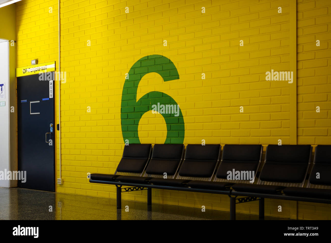 Green number 6 painted on yellow brick wall in Oulu University campus ...