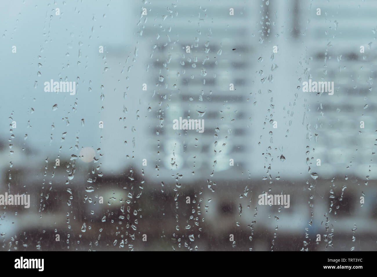 raining at windows glass with blur city building background Stock Photo ...