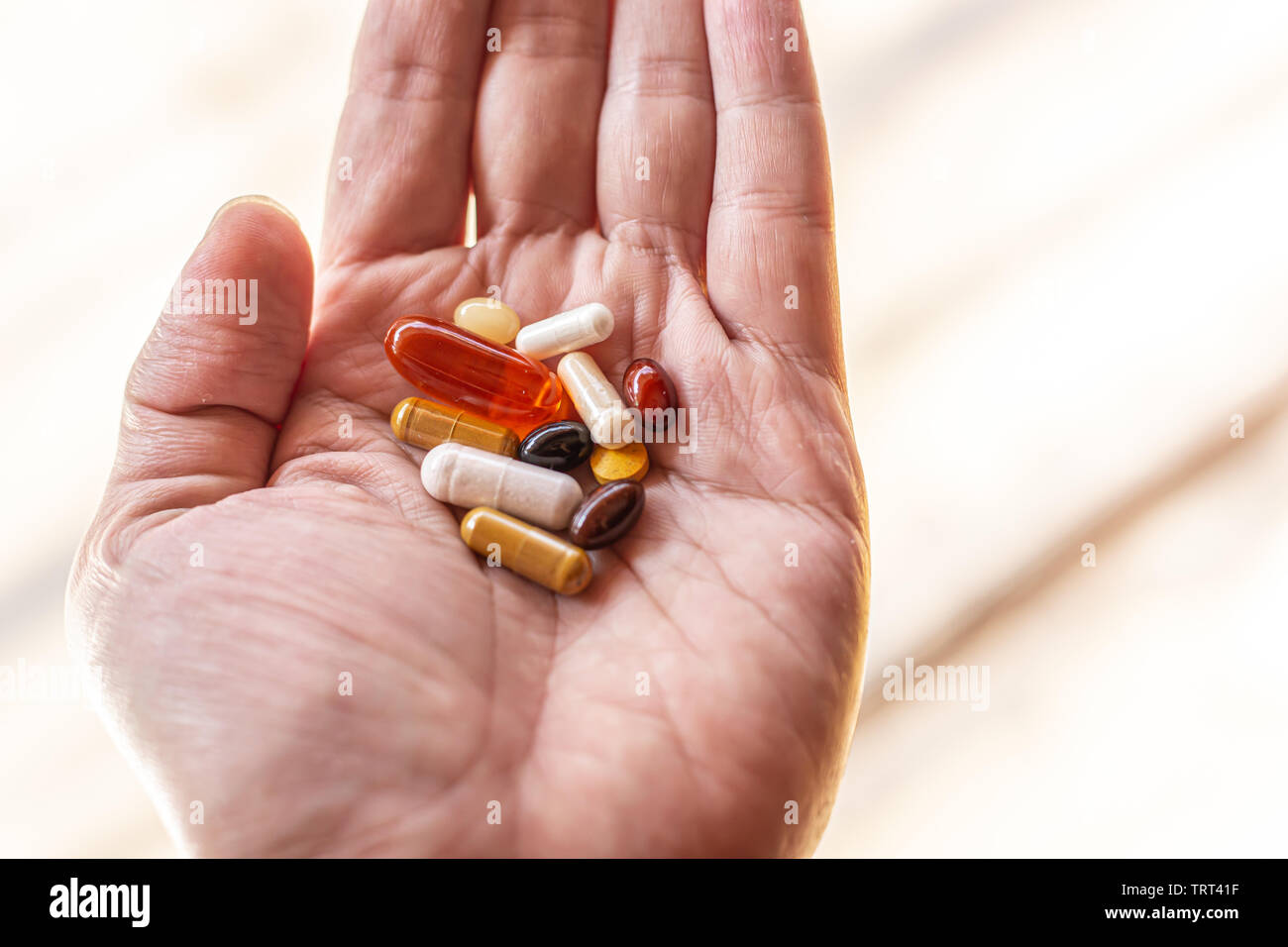 mix of many medical pills tablets of vitamin eating in male hand palm ...
