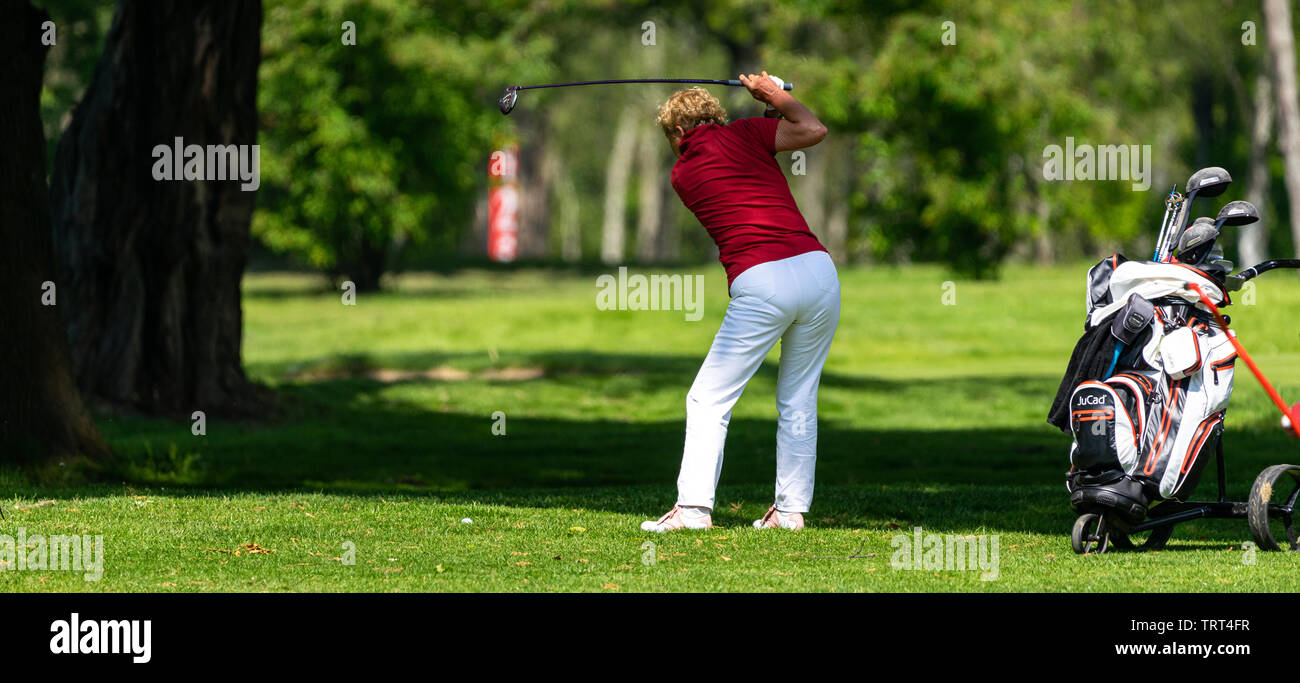 Braunschweig, Germany, May 18, 2019: Middle-aged woman hitting the golf ...