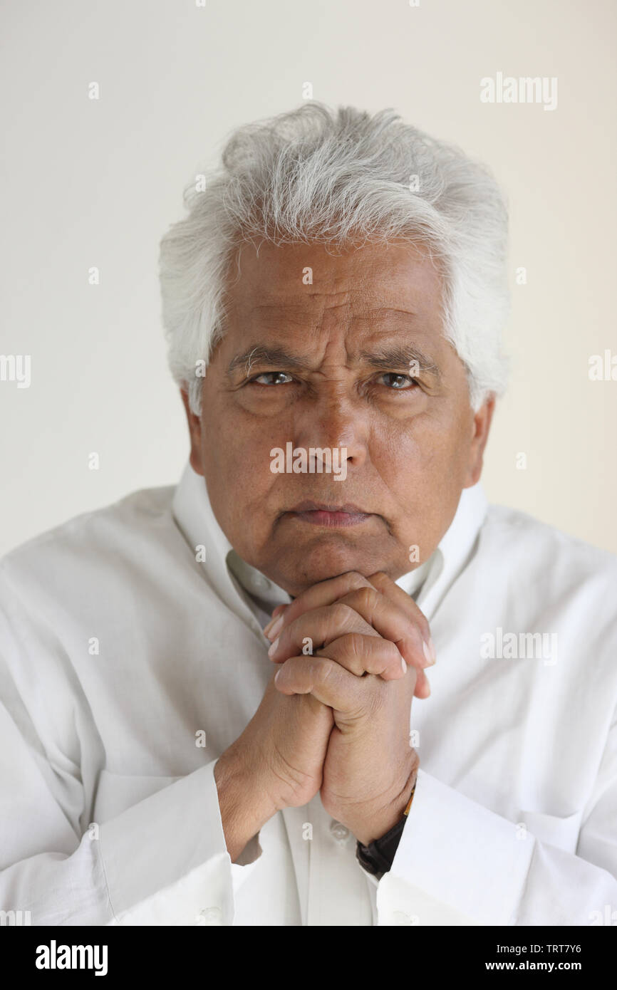 Close up of an Indian man resting chin on hands Stock Photo - Alamy