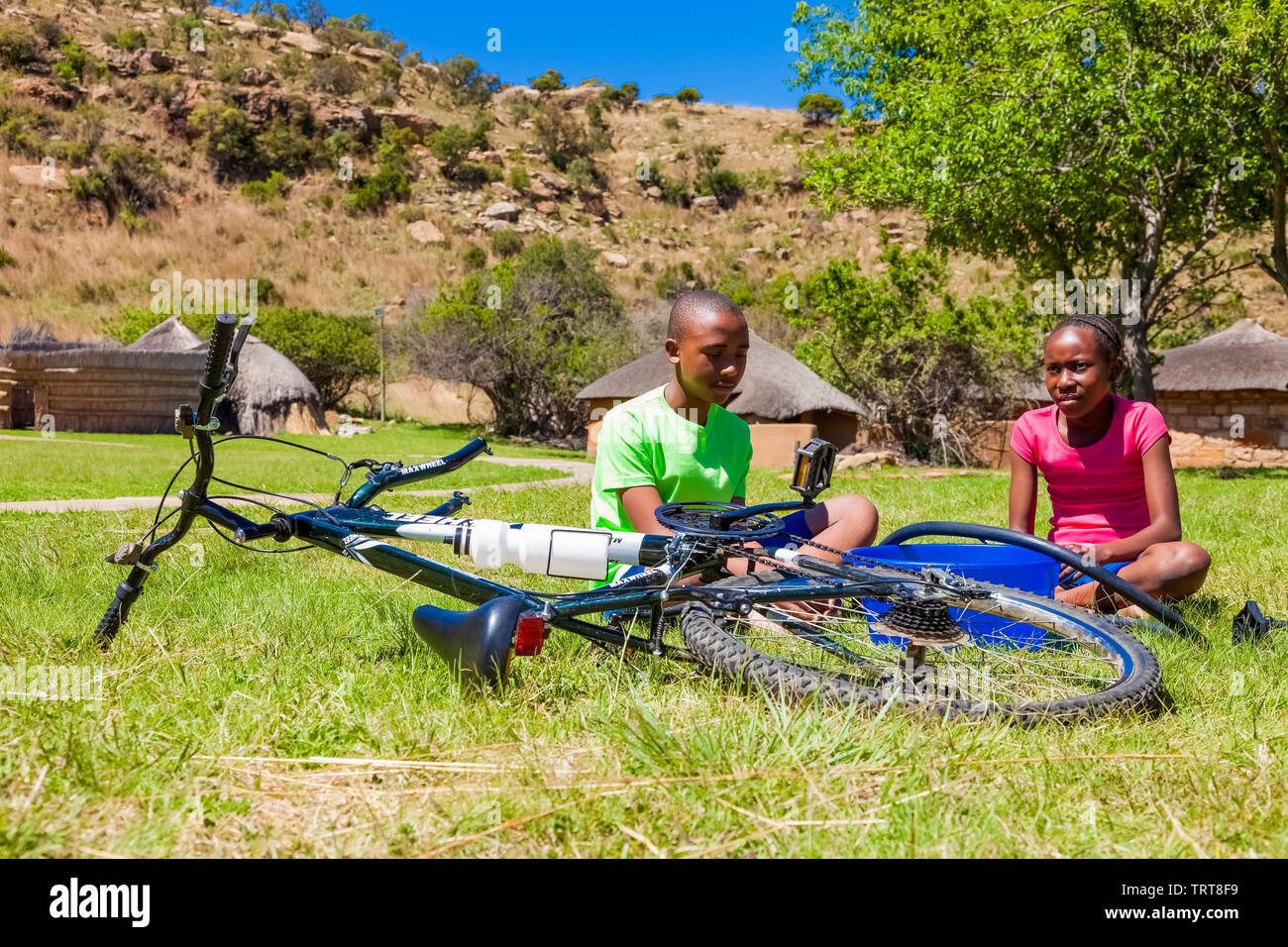 Harrismith, South Africa - October 18 2012: African Children fixing a ...