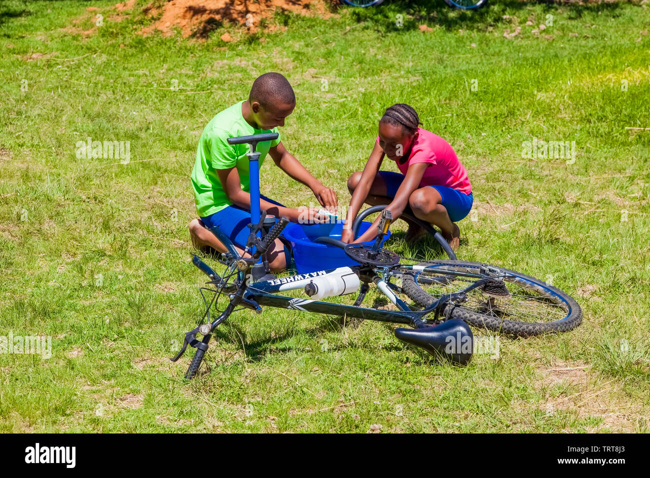 Harrismith, South Africa - October 18 2012: African Children fixing a ...