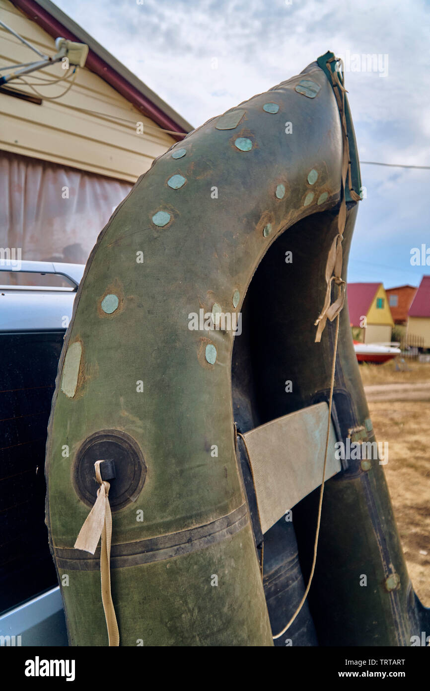 Old inflatable boat with patches from holes from hunting shot (bullets ...