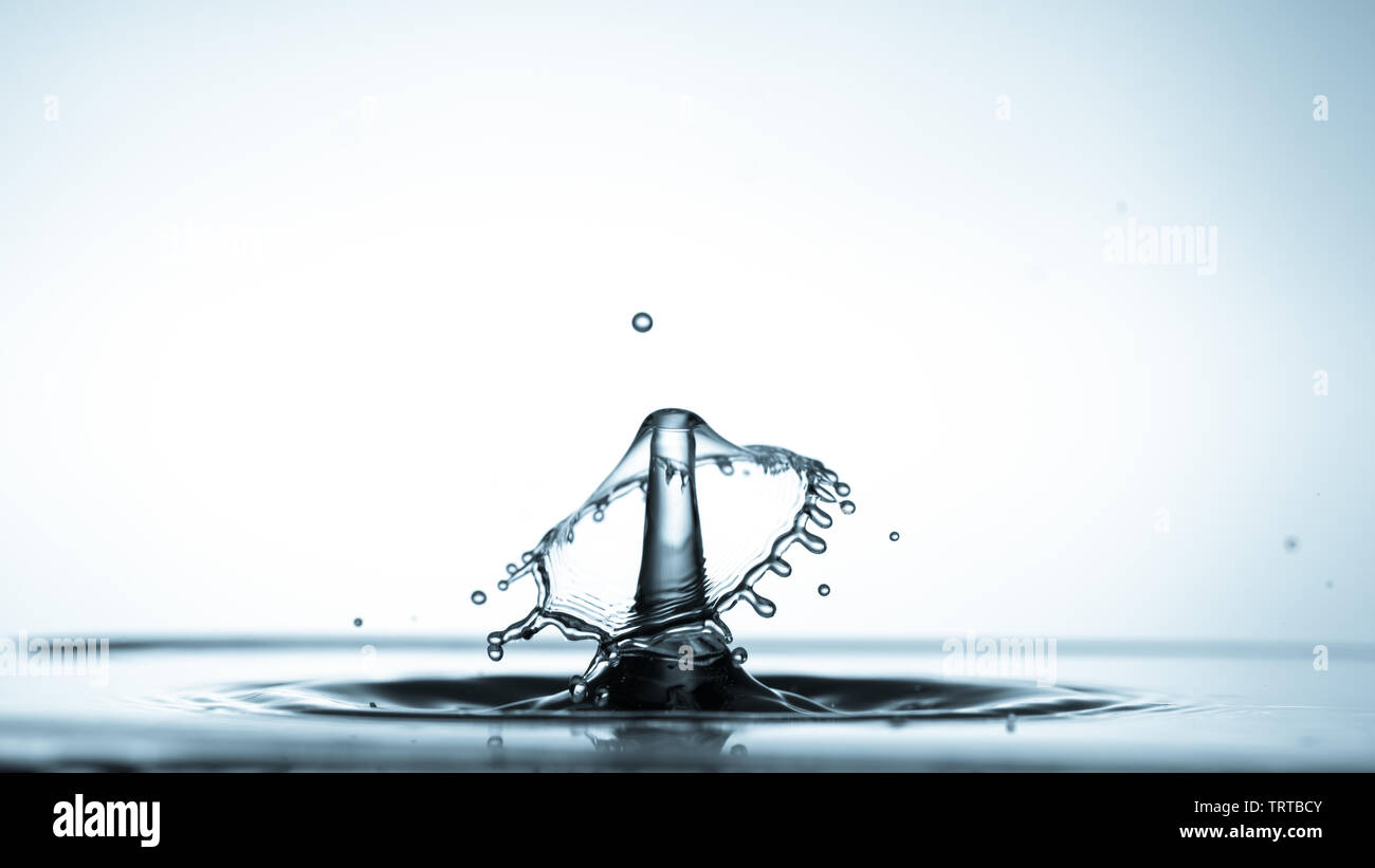 Close-up of a water drop falling on water surface Stock Photo - Alamy
