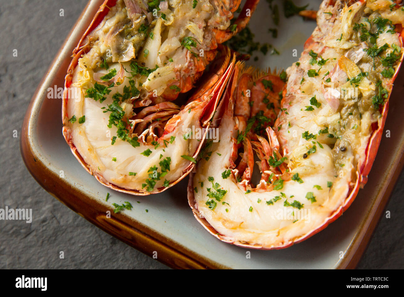 Two halves of a grilled lobster and claws from a lobster, Homarus ...