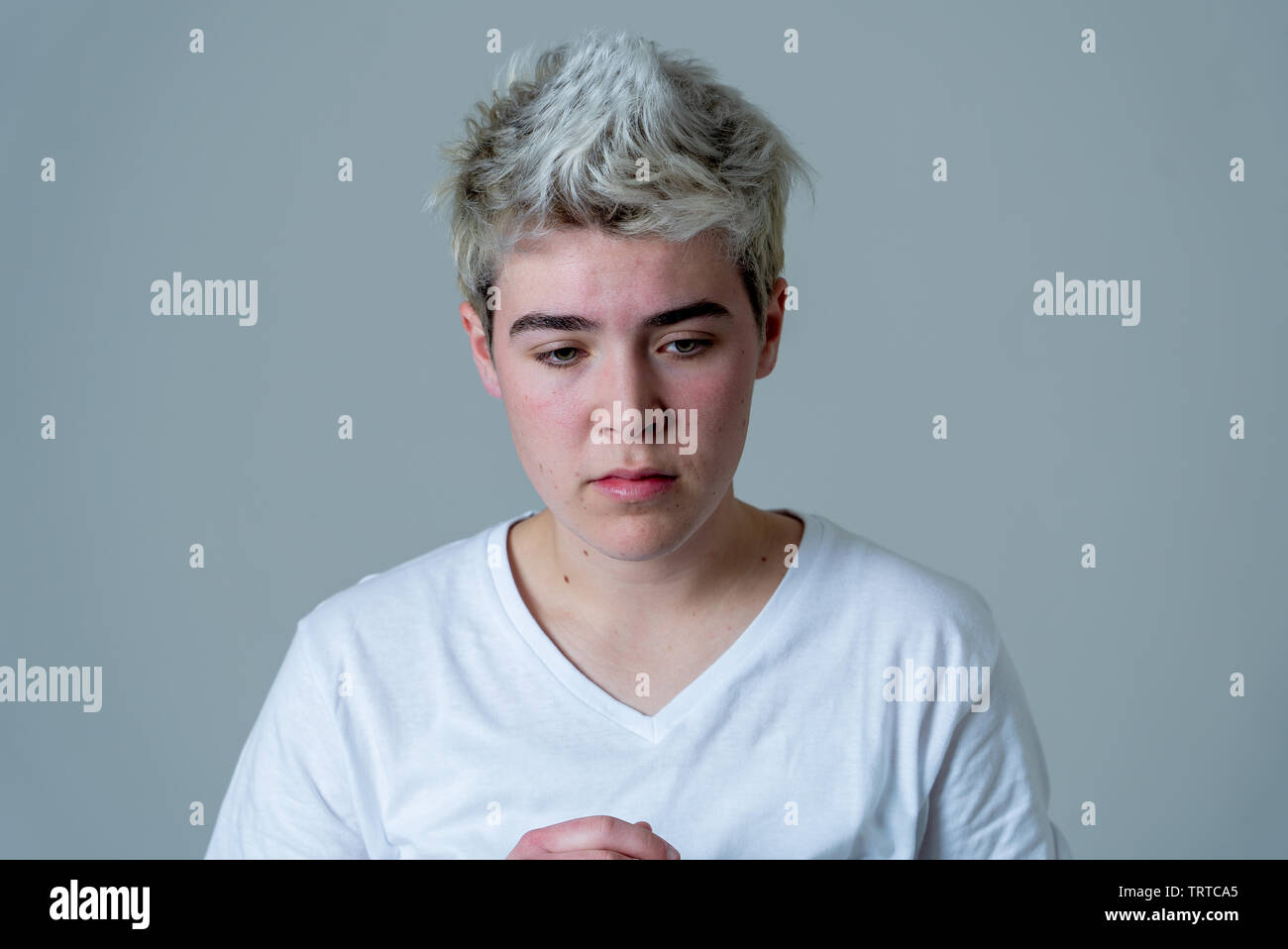 Young sad trans teenager boy suffering from depression feeling sad and ...