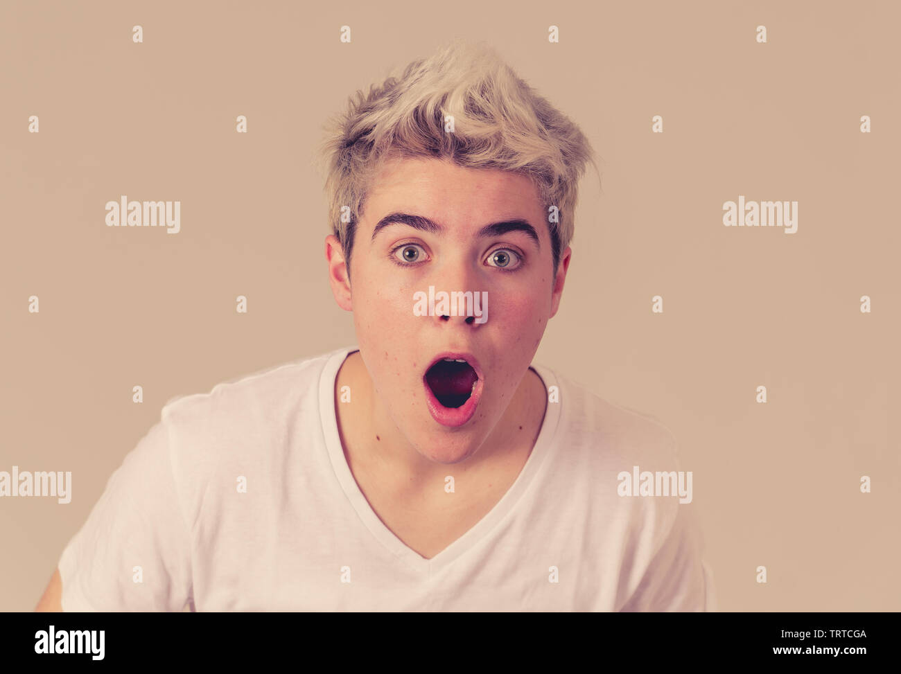 Handsome young blonde teenager boy with happy face making surprised ...