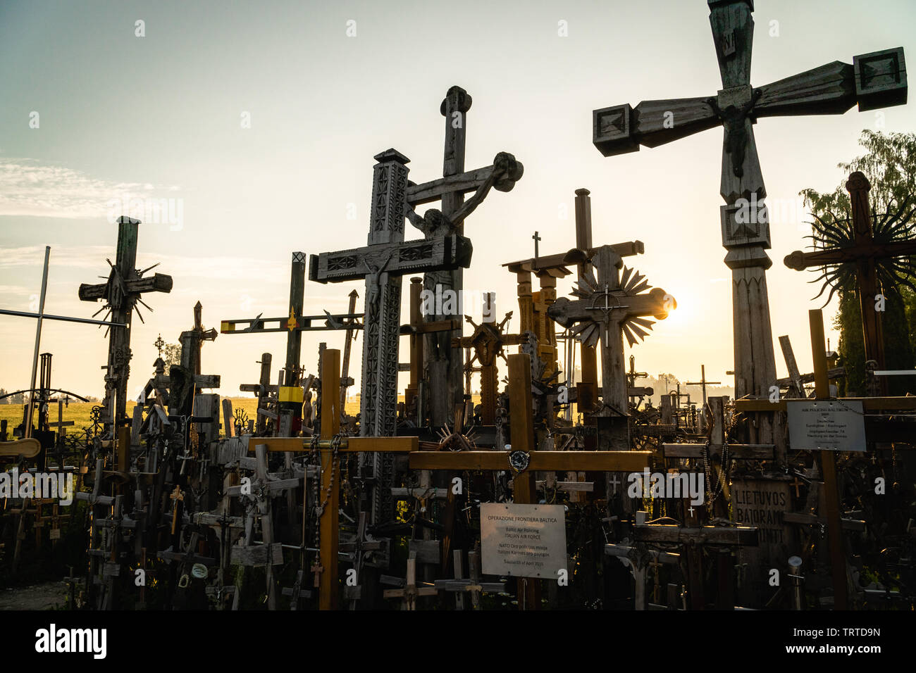 Bunch of wooden crosses with rising sun in background. Hill of Crosses ...