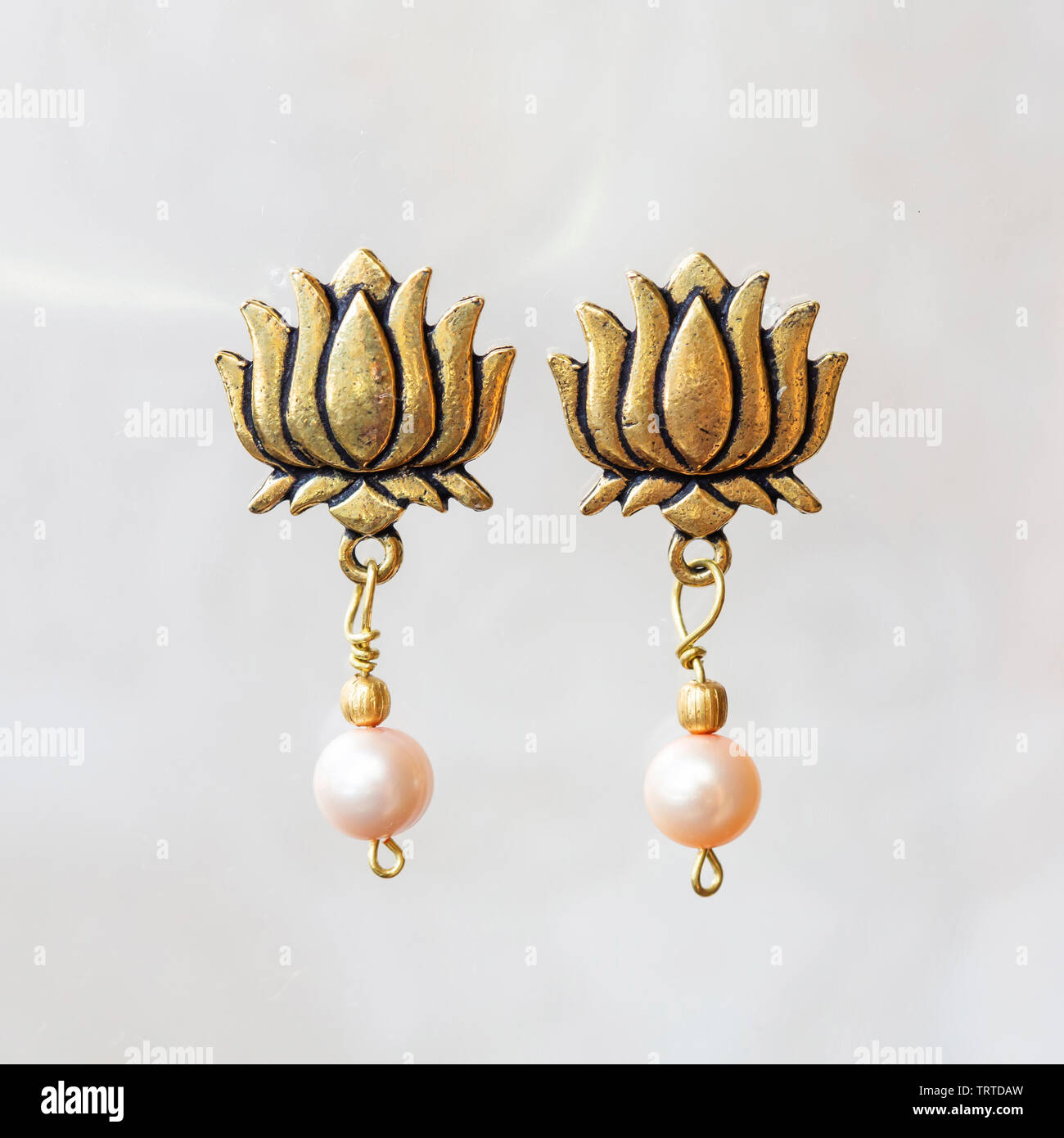 pearl beads lotus shape earrings on neutral background Stock Photo - Alamy