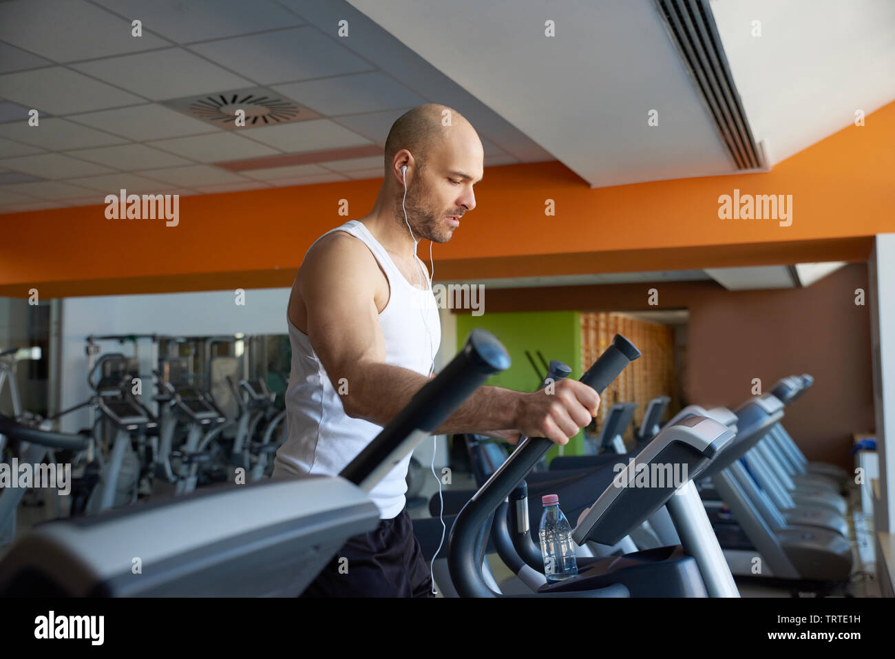 Sporty man is working out in gym. Doing cardio training on treadmill ...