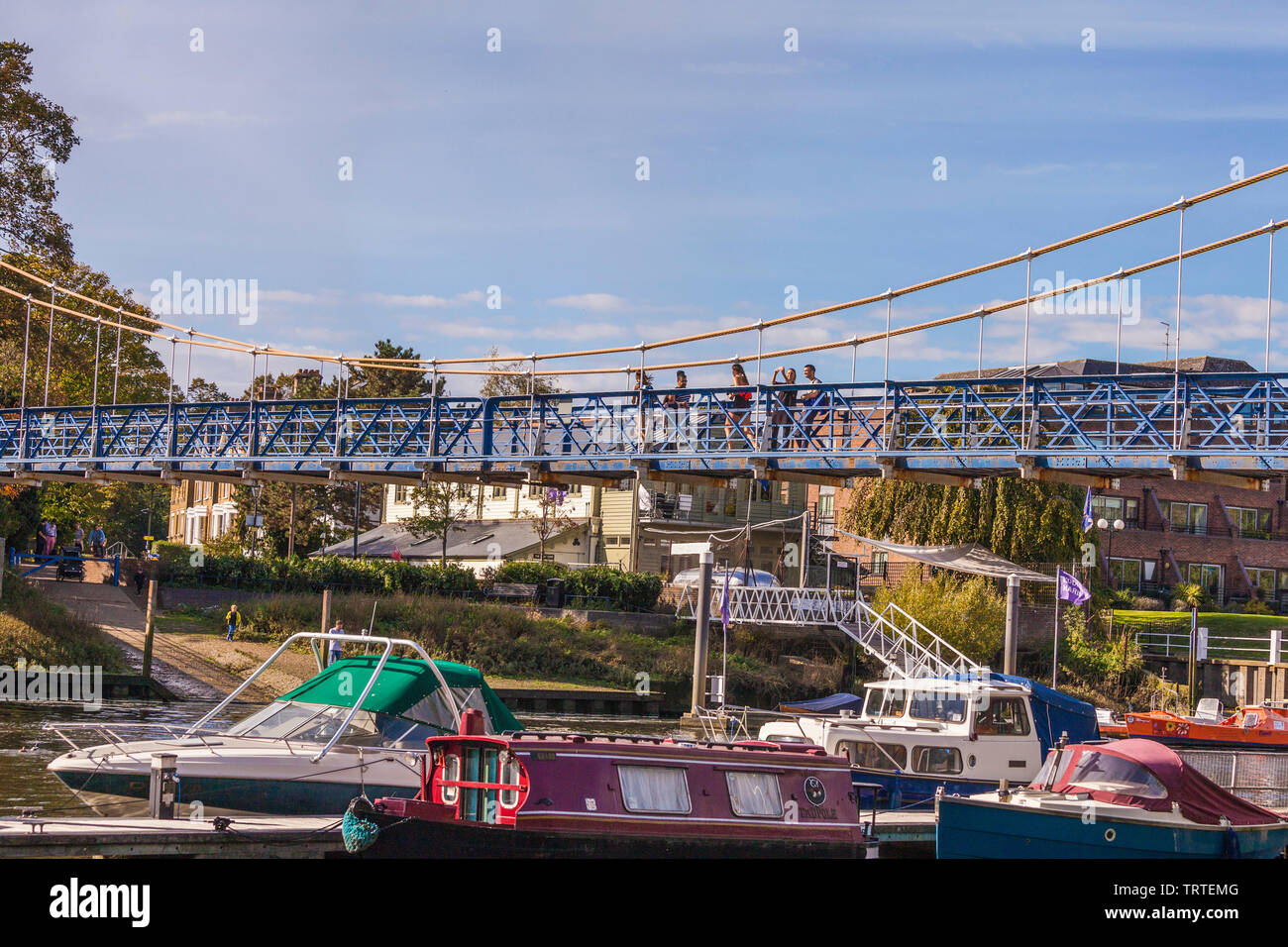 People crossing the footbridge over the River Thames at Teddington ...