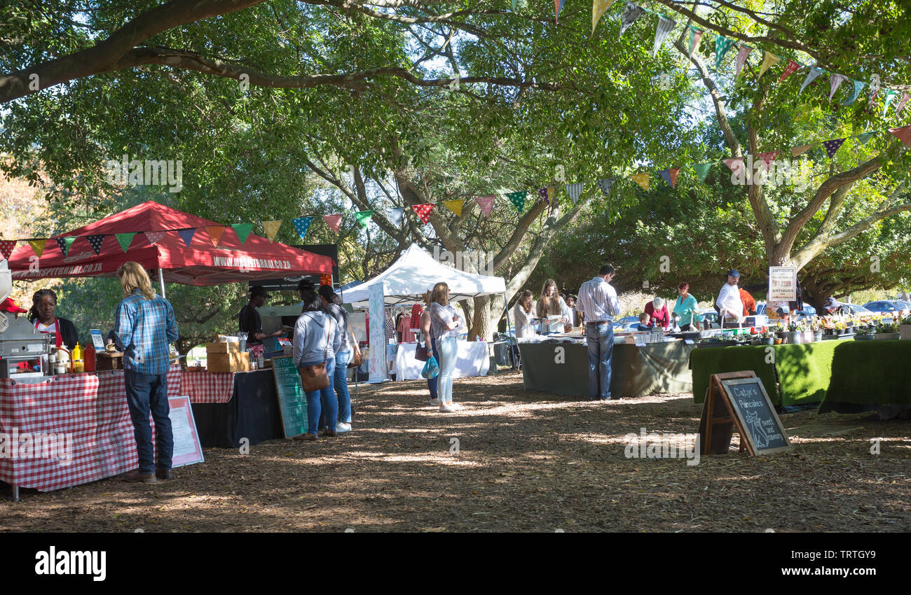 people enjoying an outdoor market under the trees on an Autumn day in ...