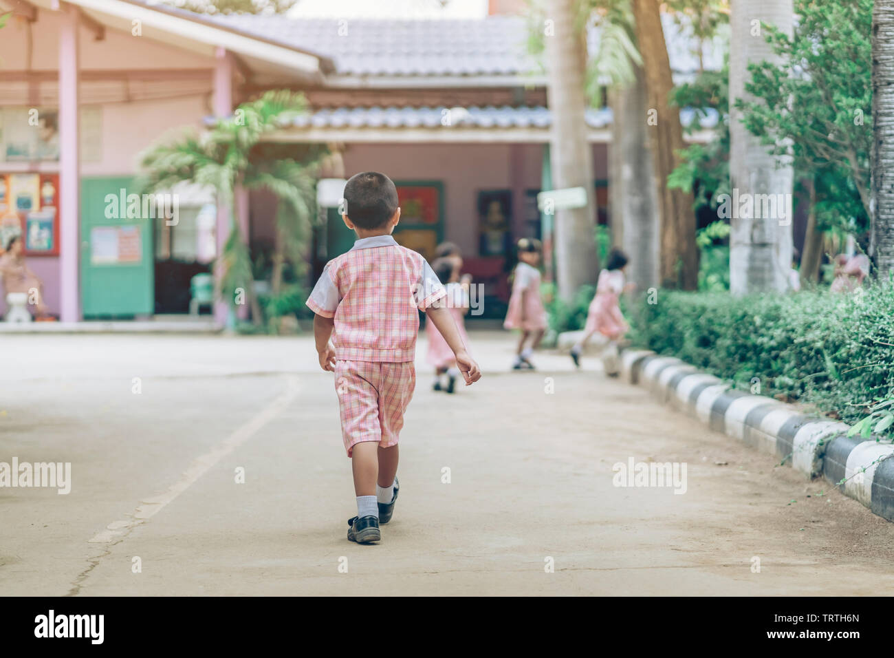 Back view of Boy followed girl friends on street to go to the classroom ...