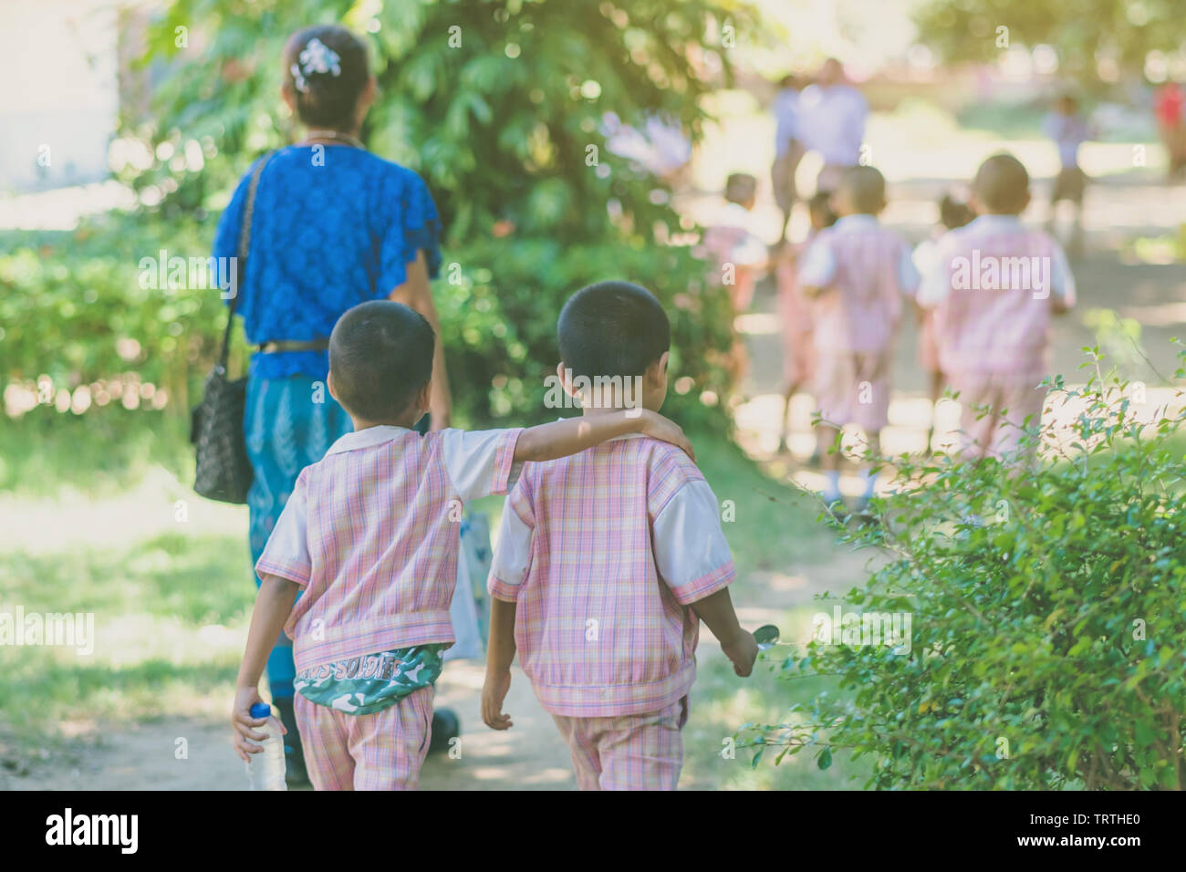 Kindergarten boy walk after female teacher and his friends back to ...
