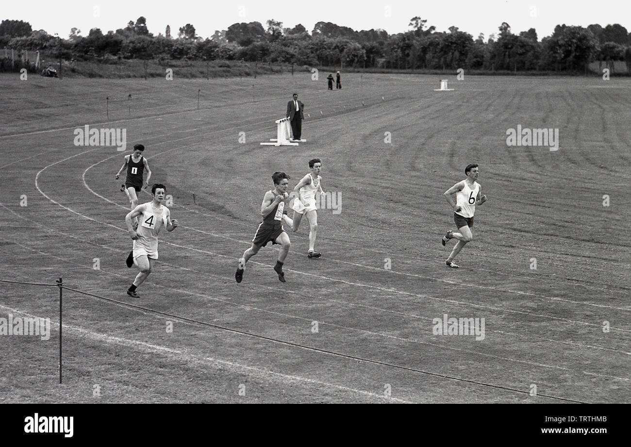 1950s, historical, young male athletes competing in a running race ...
