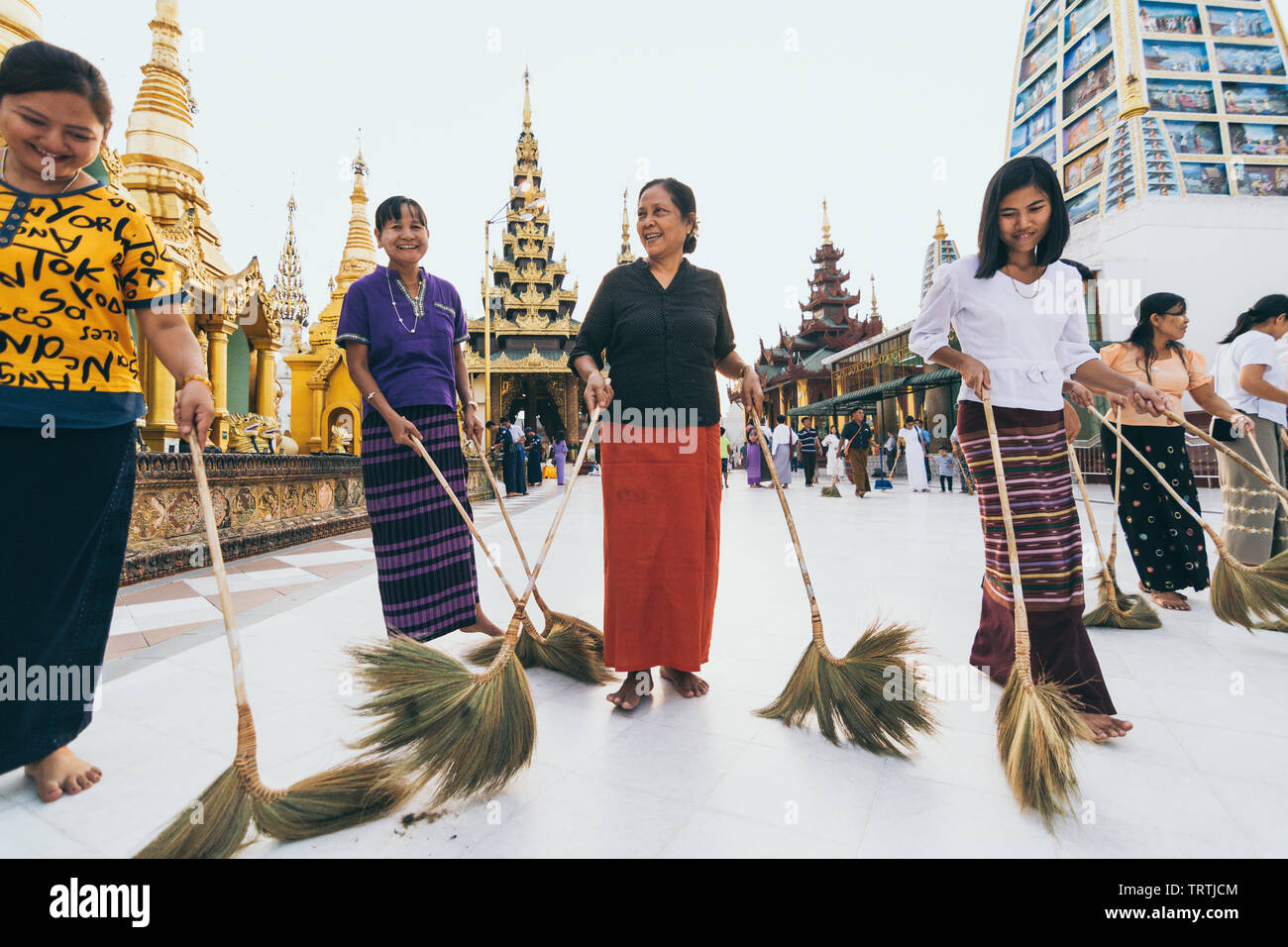 Yangon, Myanmar - March 2019: Burmese women swipe the floor with brooms ...