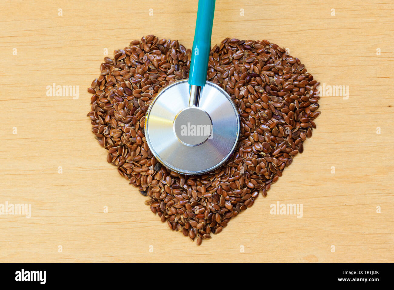 Diet healthcare and checkup concept. Raw flax seeds linseed heart shaped and stethoscope ...