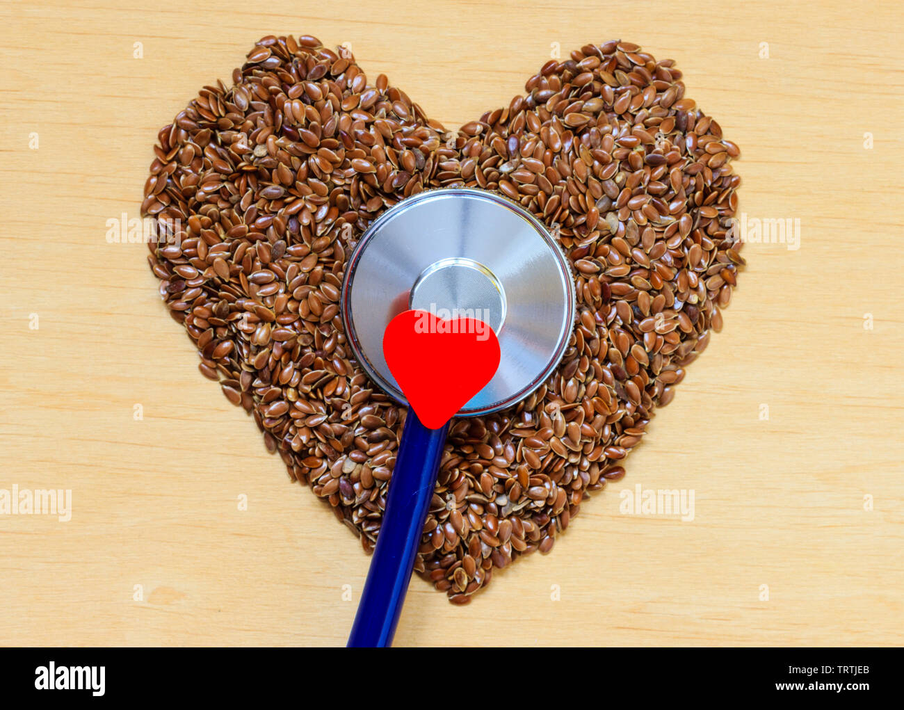 Diet healthcare and checkup concept. Raw flax seeds linseed heart shaped and stethoscope ...