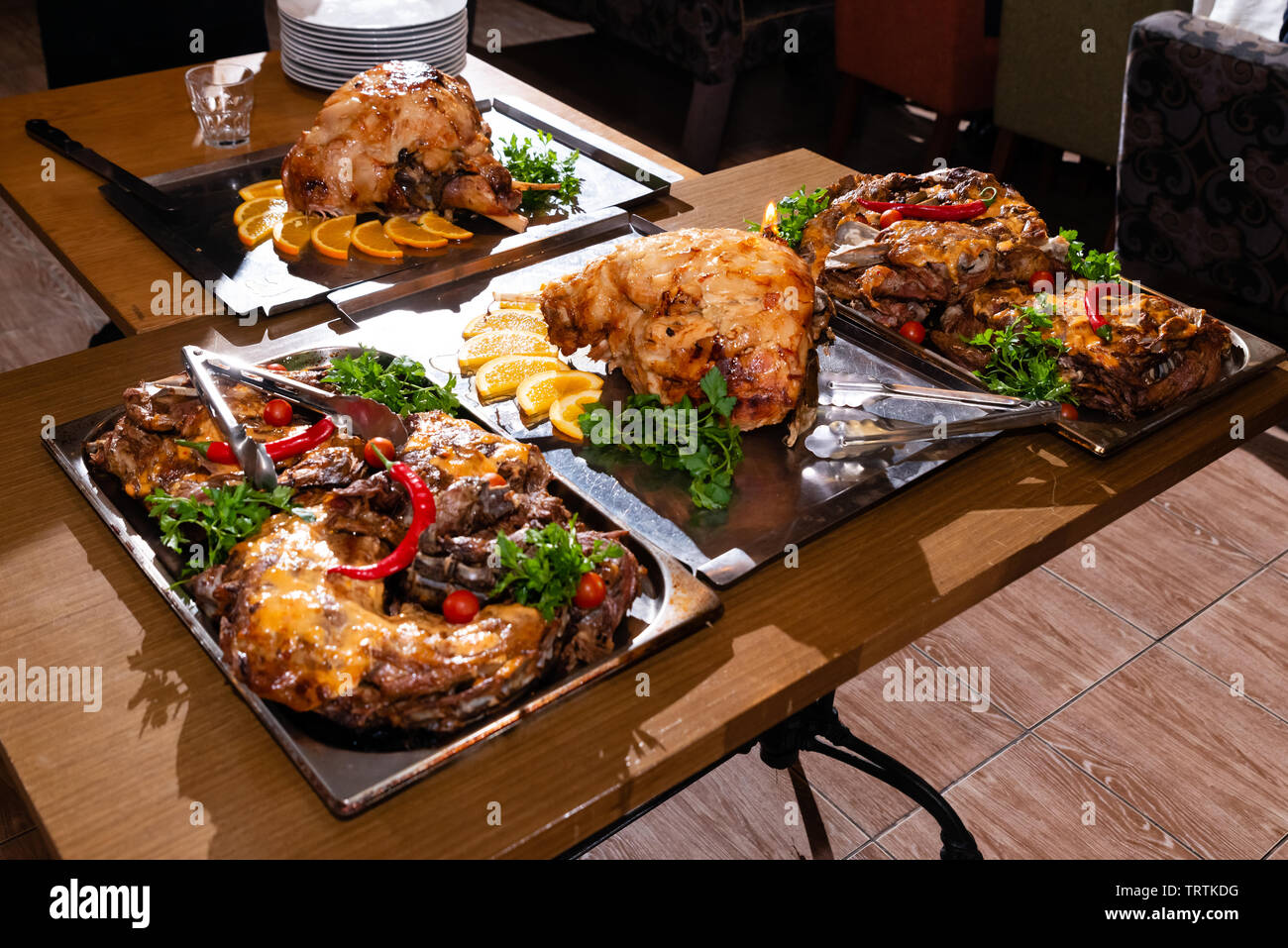 baked pork knuckle on a metal tray on the serving table in the ...