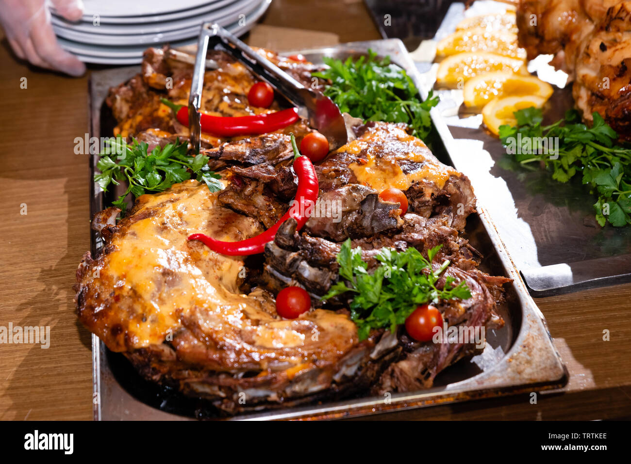 baked pork knuckle on a metal tray on the serving table in the ...