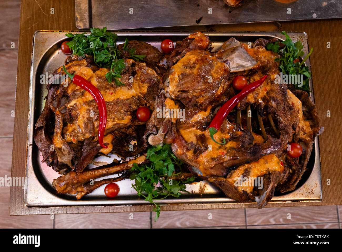 baked pork knuckle on a metal tray on the serving table in the ...