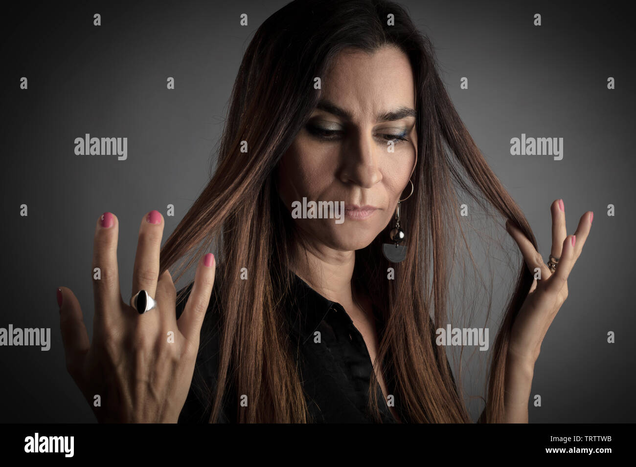 Portrait of middle-aged woman, half body with gray background shaking ...