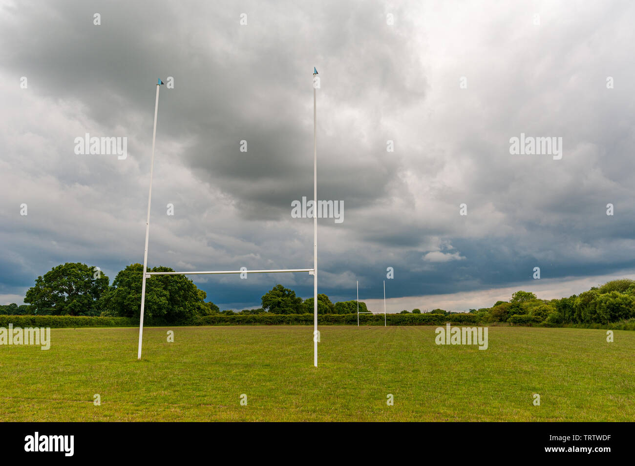 Rugby pitch and white post with dark sky thunder clouds above Stock ...