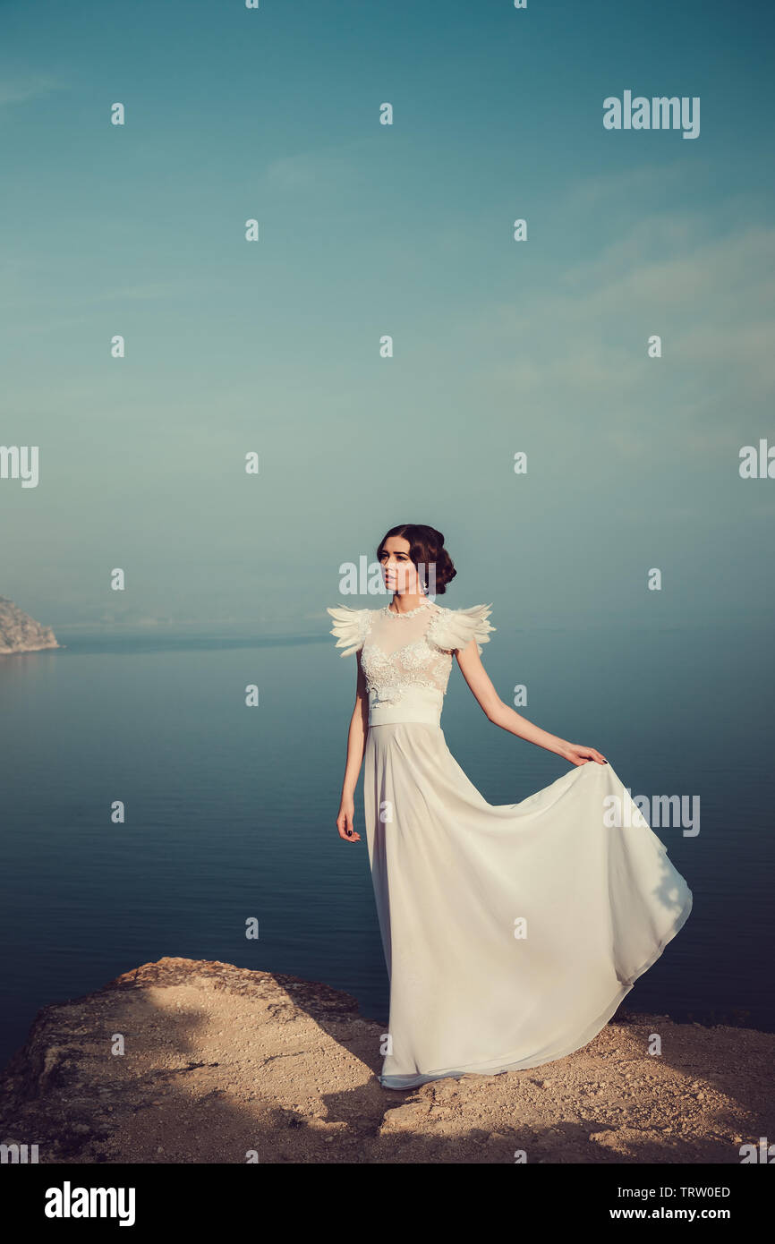 Beautiful bride posing on the coast with angelic dress. Bride in ...