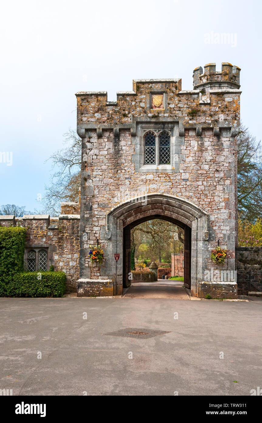 A drive leads up from attractive parkland through the archway of a two ...