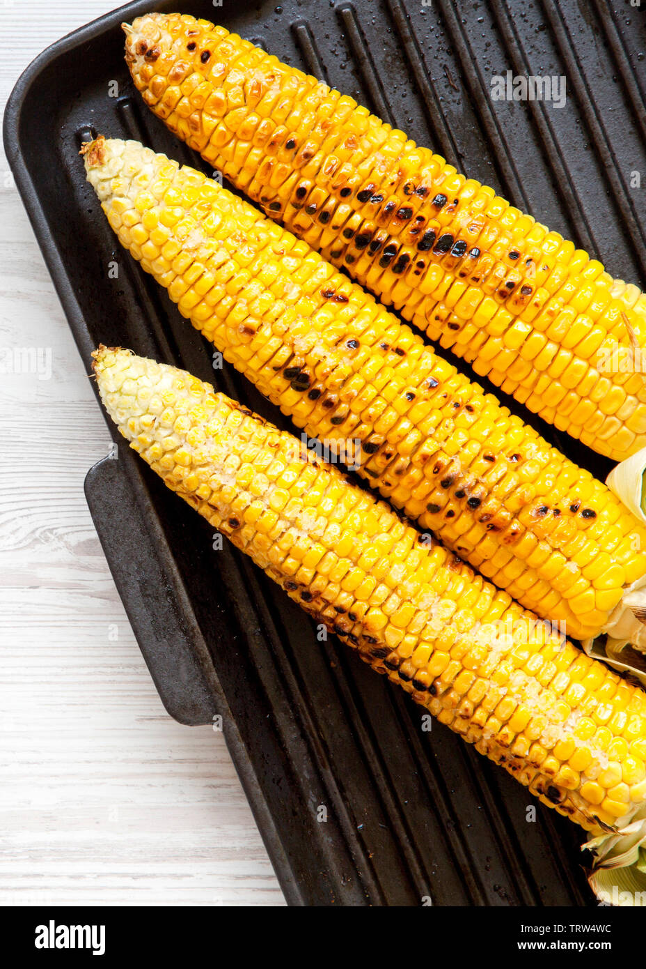 Grilled corn on the cob in a grilling pan, top view. Overhead, from ...