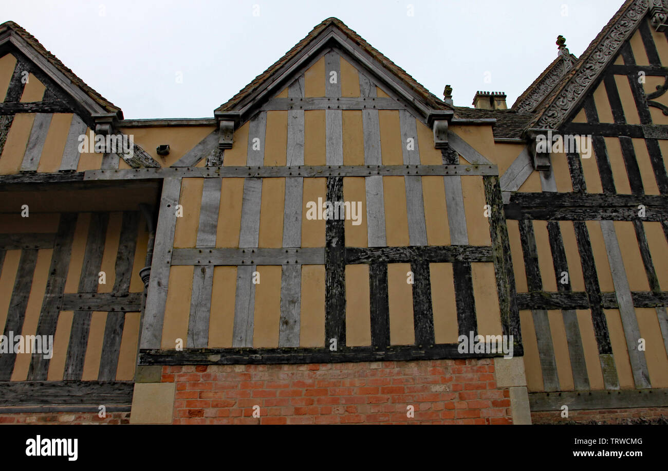 Part of a half timber framed building with ornate carvings on some of ...