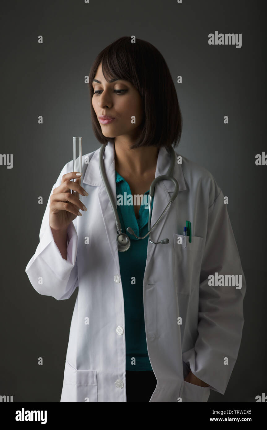 Female doctor looking at a test tube Stock Photo - Alamy