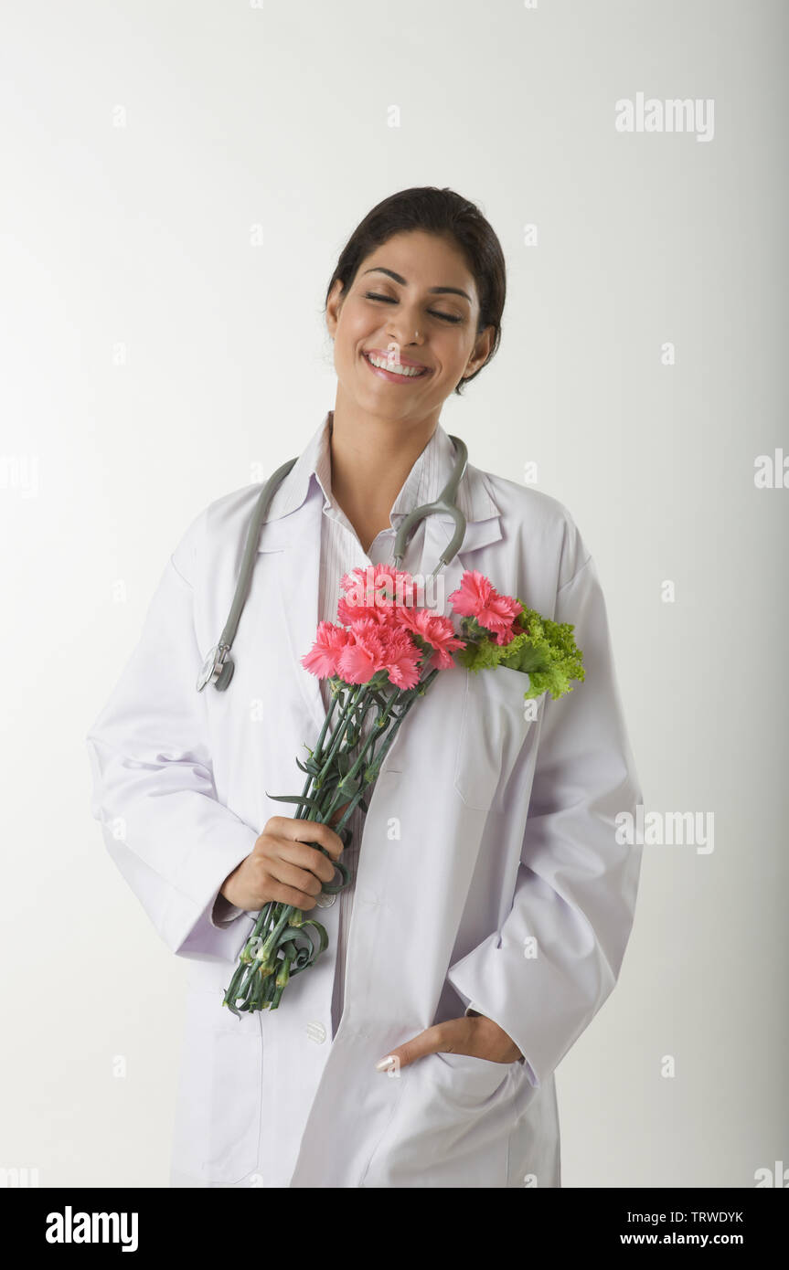 Female doctor holding bunch of flowers and smiling Stock Photo - Alamy